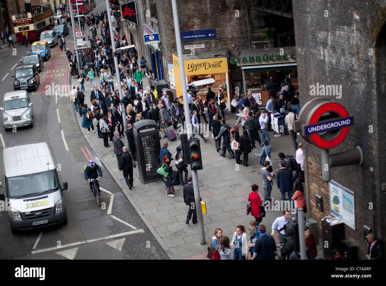 Commuters enter the London Bridge Underground station during rush hour ...