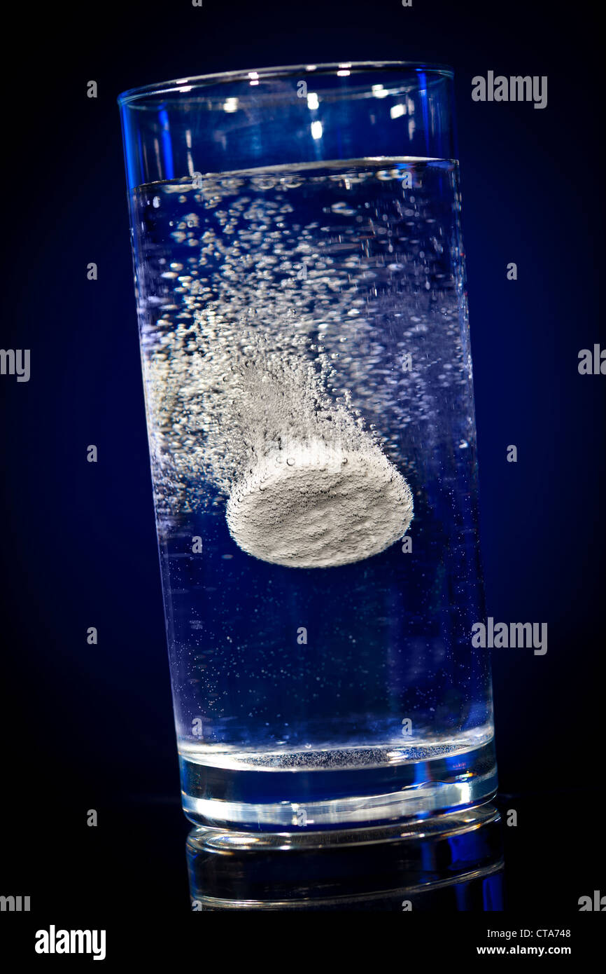 Effervescent tablet in water with bubbles on a blue background Stock ...
