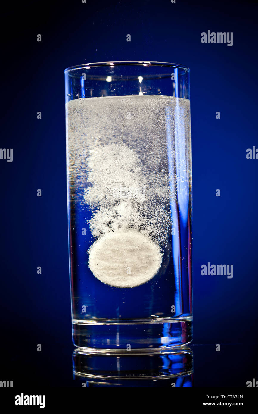 Effervescent tablet in water with bubbles on a blue background Stock ...