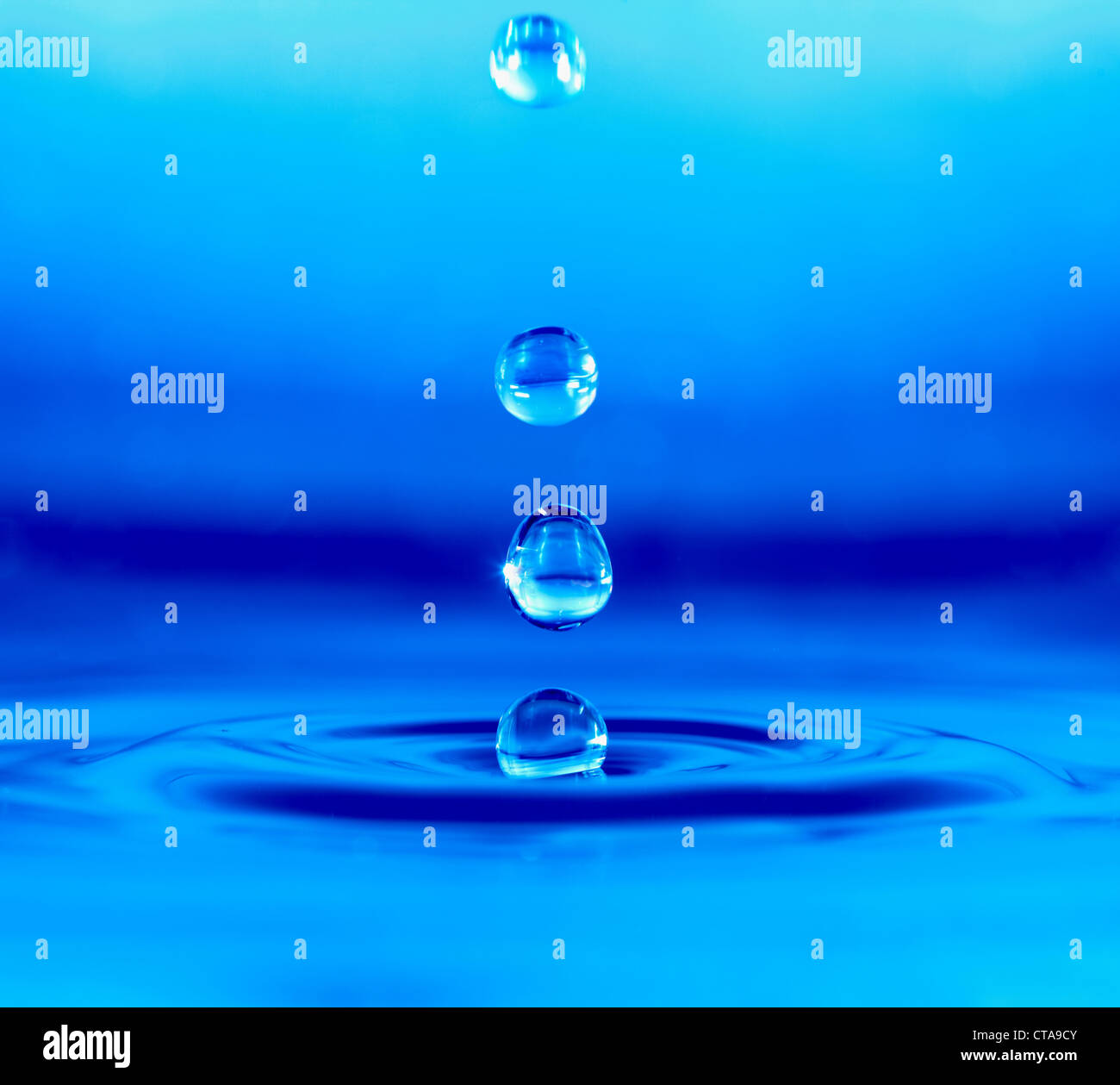 Falling drop of blue water Stock Photo - Alamy