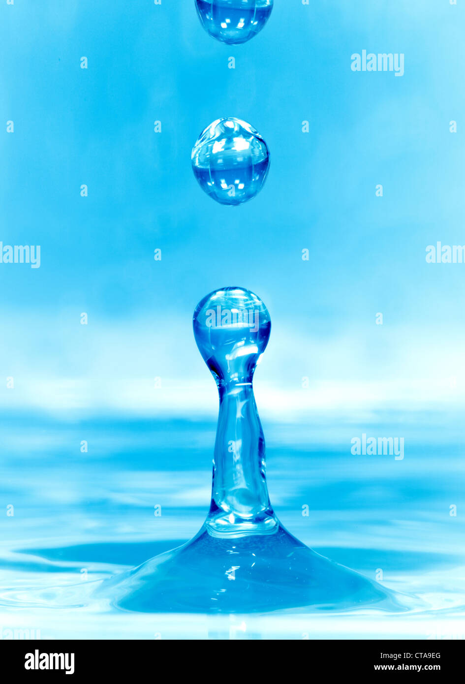 Falling drop of blue water Stock Photo - Alamy