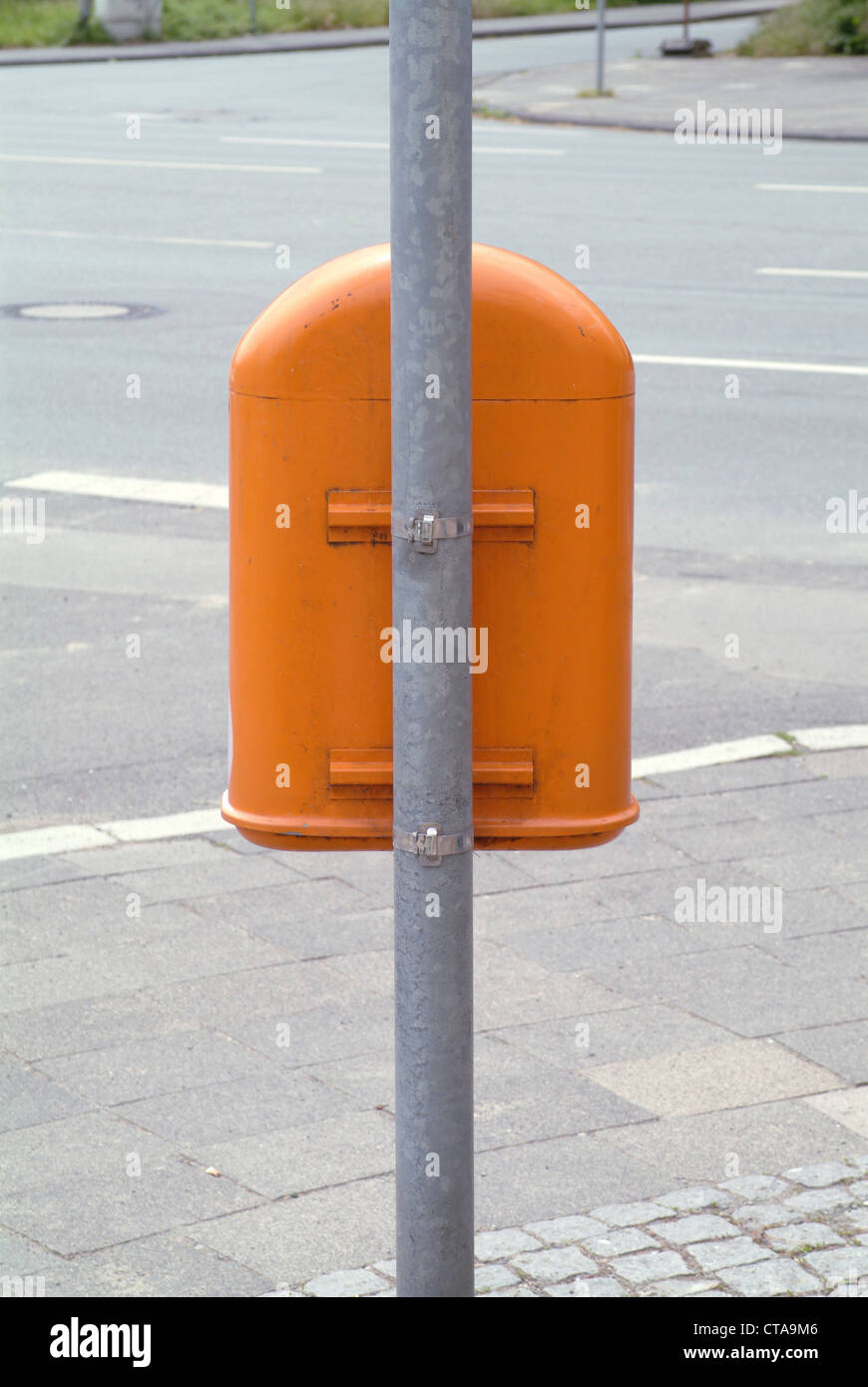 Orange trash can on a pole Stock Photo - Alamy