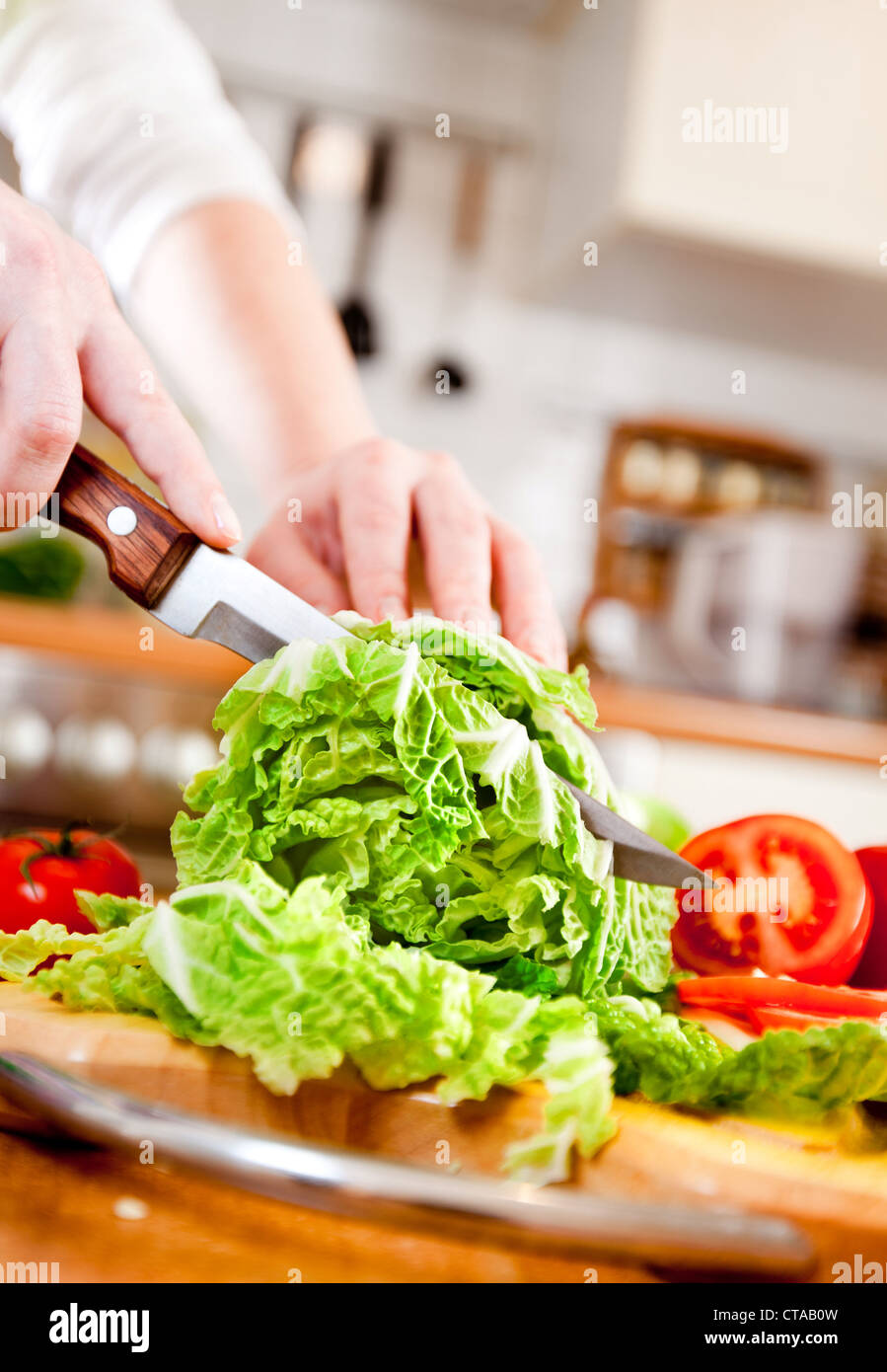 Woman's hands cutting lettuce, behind fresh vegetables Stock Photo - Alamy