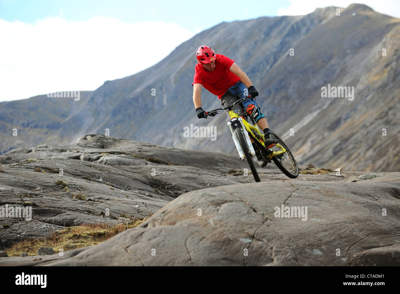 A mountain biker riding over rock in the Wester Ross area of the the ...