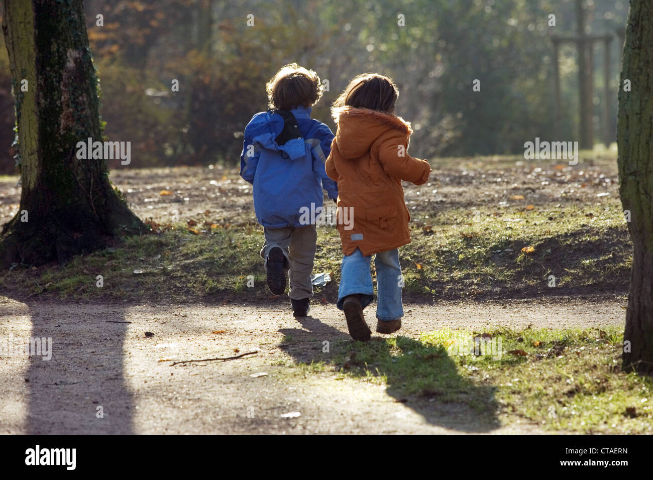 Two children running in the woods Stock Photo - Alamy