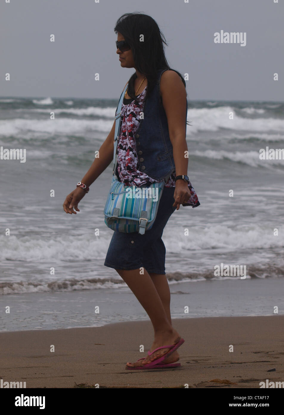 Asian woman walking along the beach, Cornwall, UK Stock Photo - Alamy