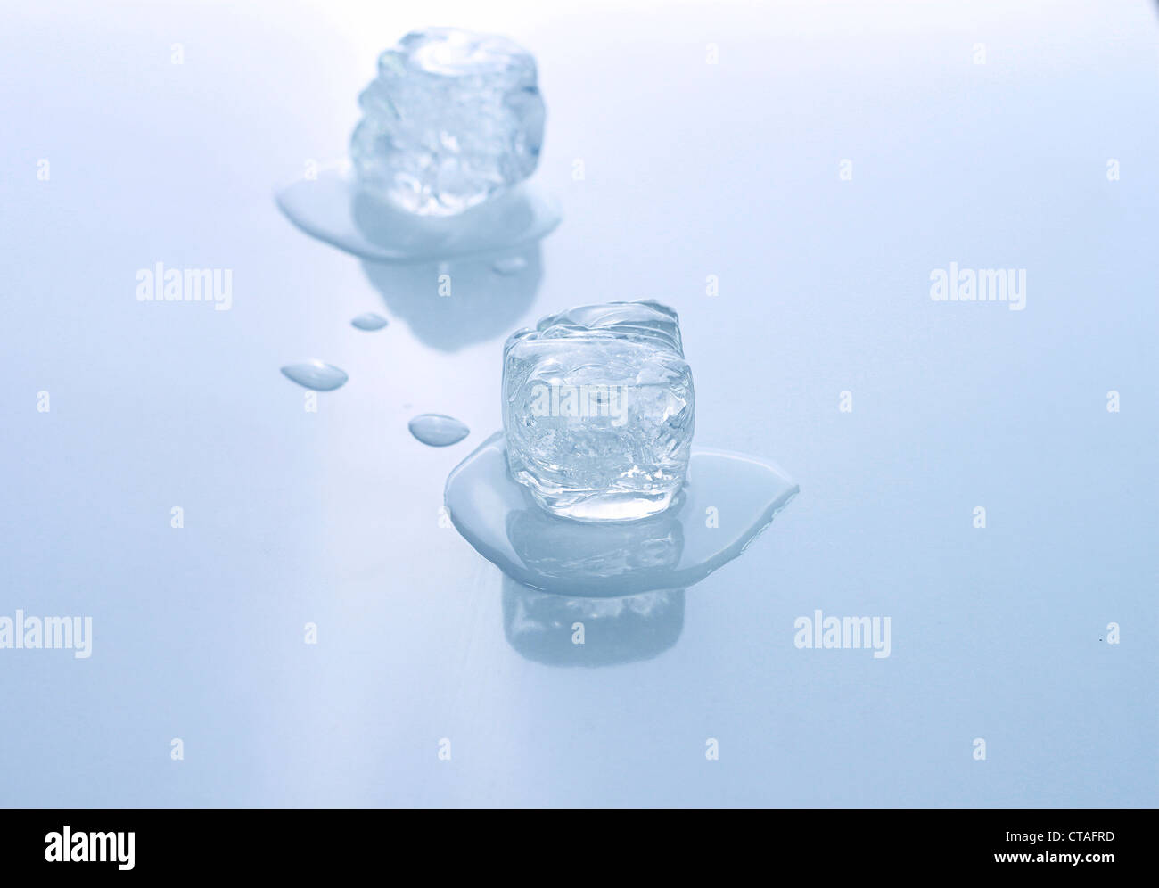 Two blue colored ice cubes melted in water Stock Photo - Alamy