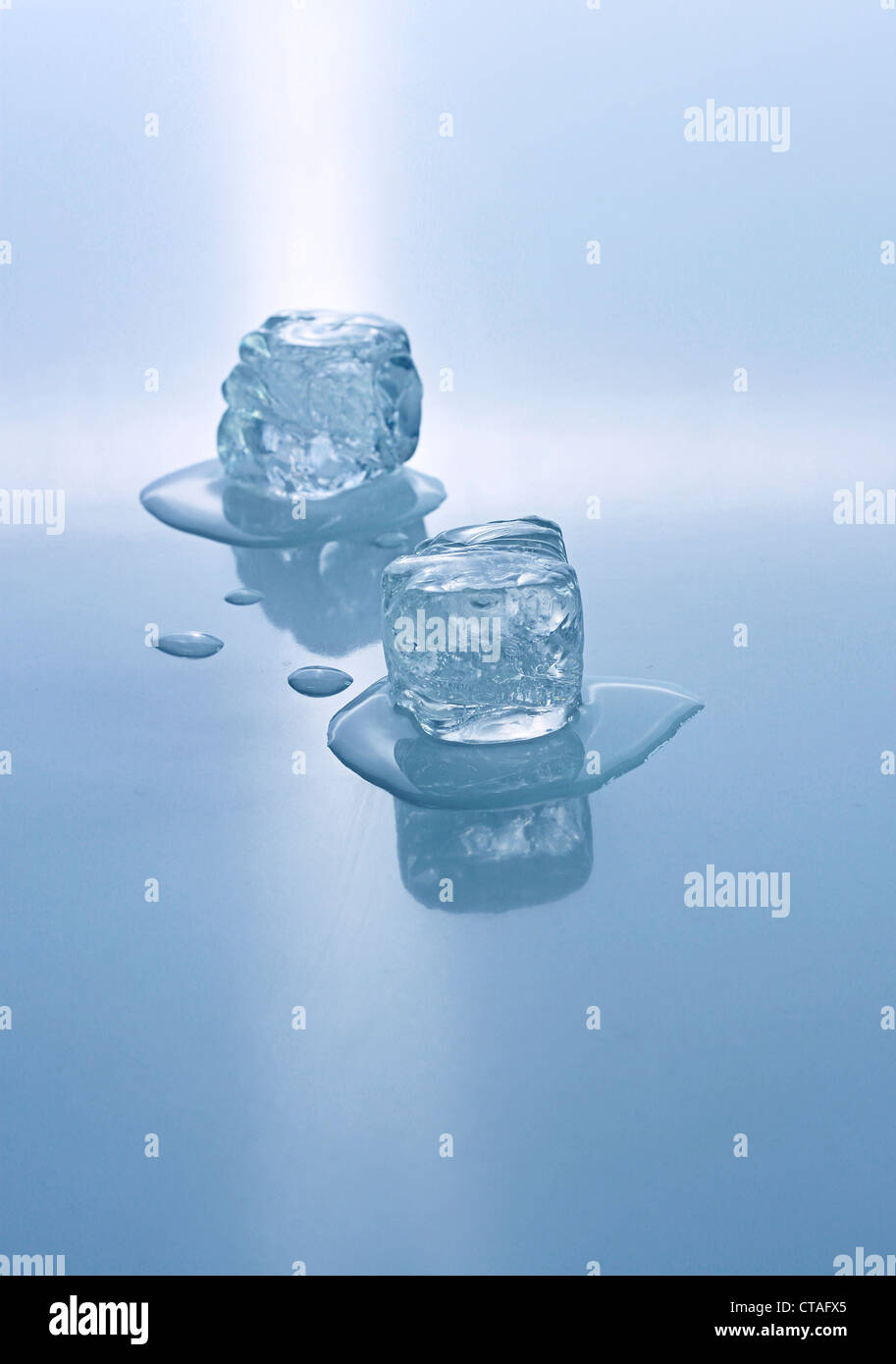 Two blue colored ice cubes melted in water Stock Photo - Alamy