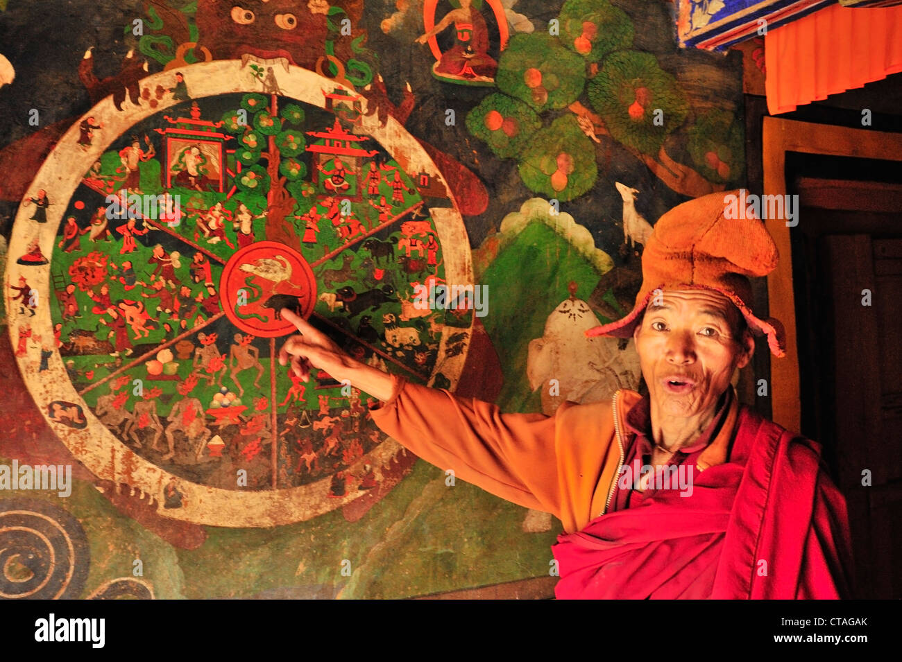 Yellow-hat monk explaining wheel of life, monastery of Lingshed ...
