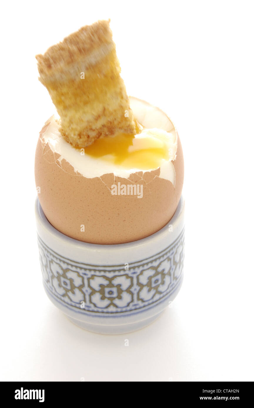Open soft boiled egg and motion-blurred toast finger isolated on a ...
