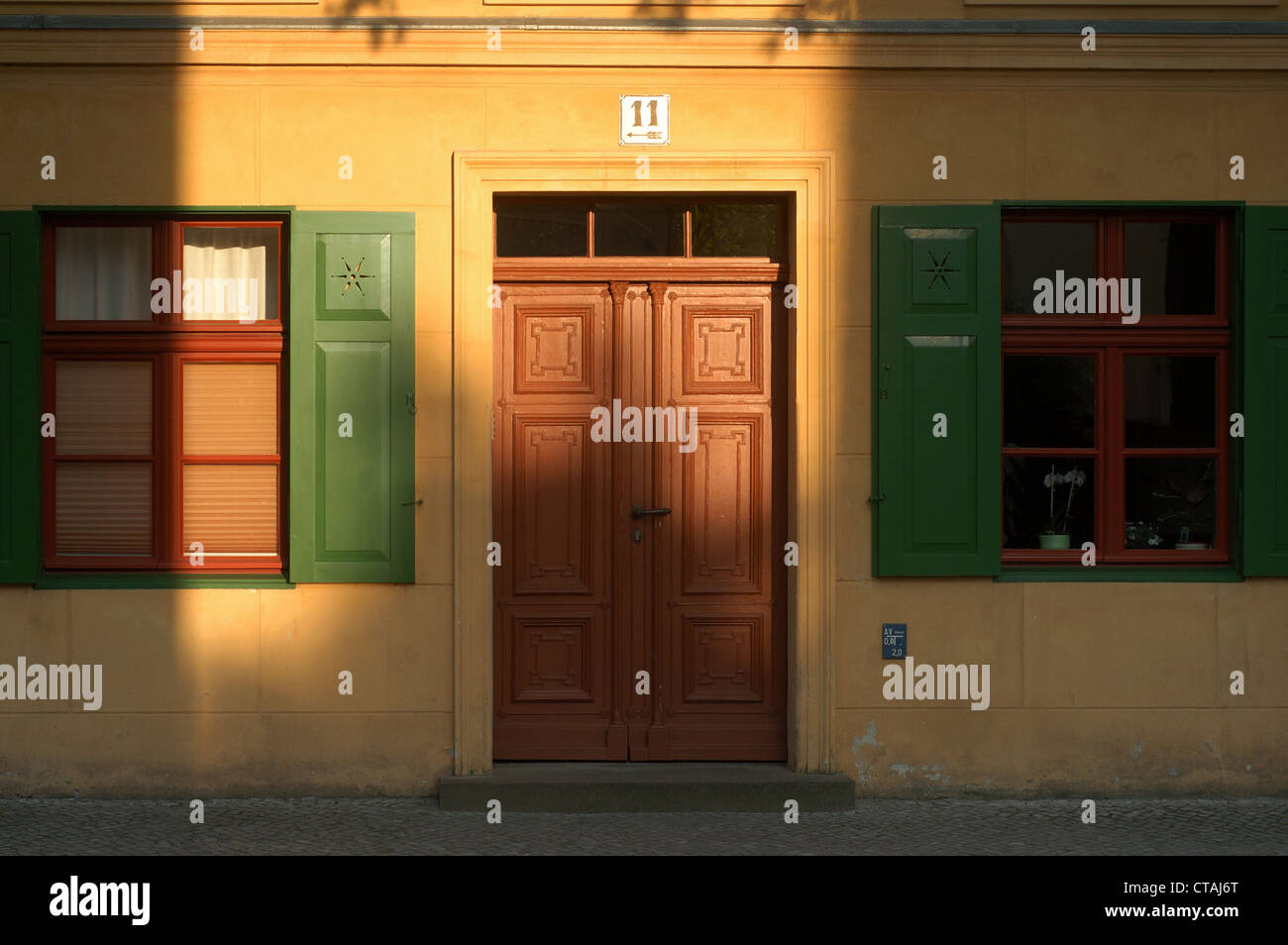 Yellow facade of an old house in the evening light Stock Photo - Alamy