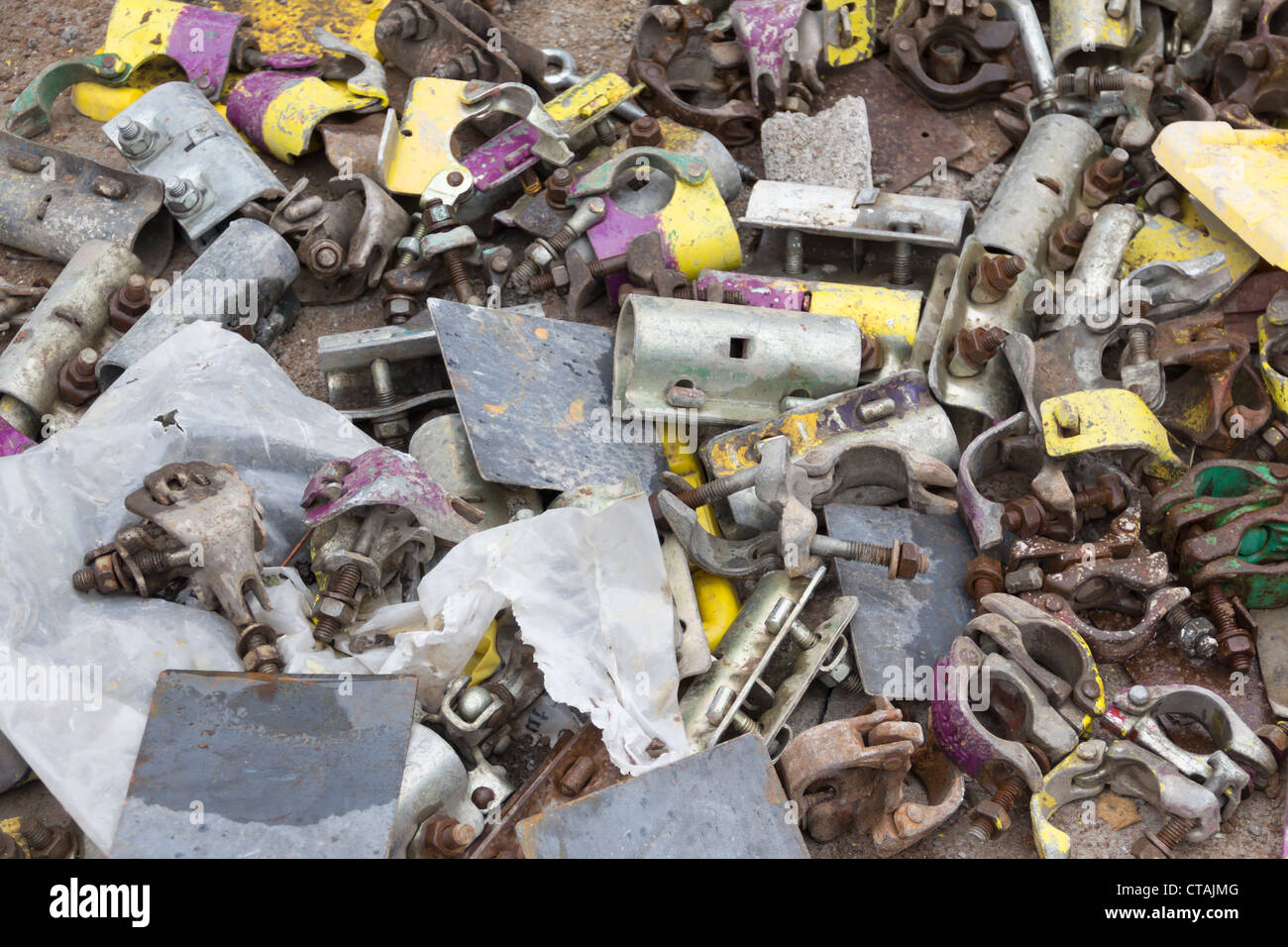 Dismantled scaffolding couplings and parts scattered on the ground on a ...