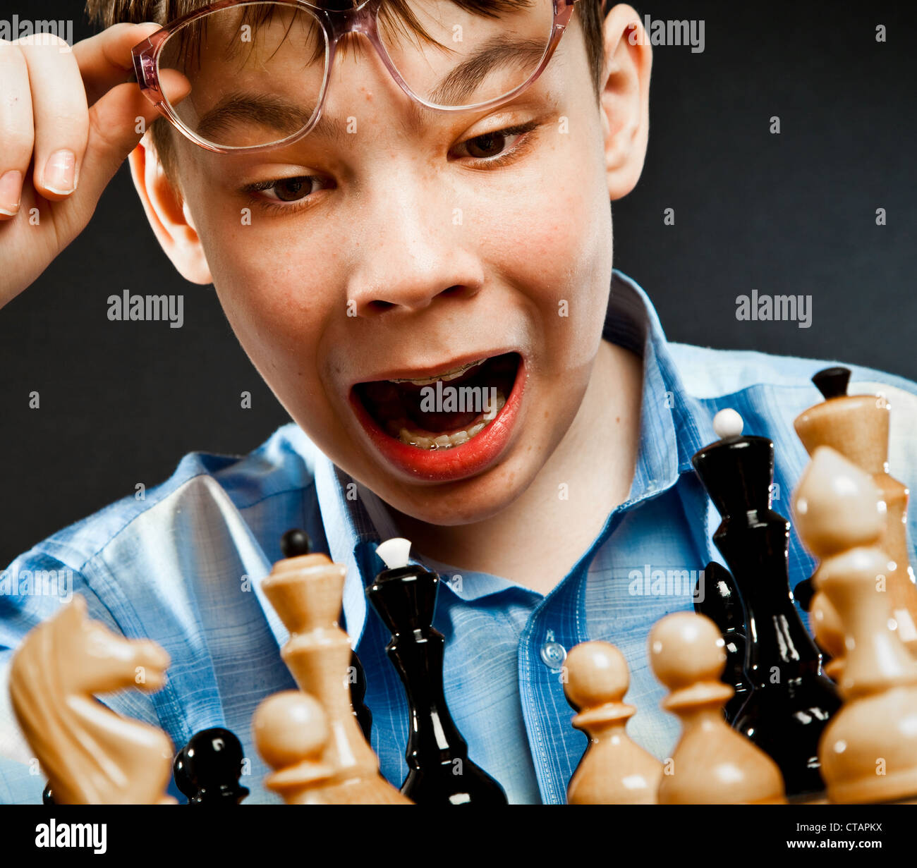 Nerd play chess on a black background Stock Photo - Alamy