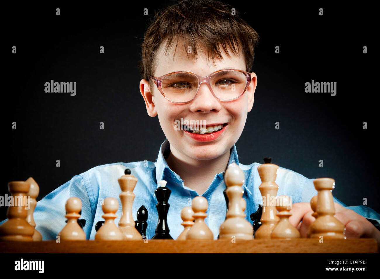 Nerd play chess on a black background Stock Photo - Alamy