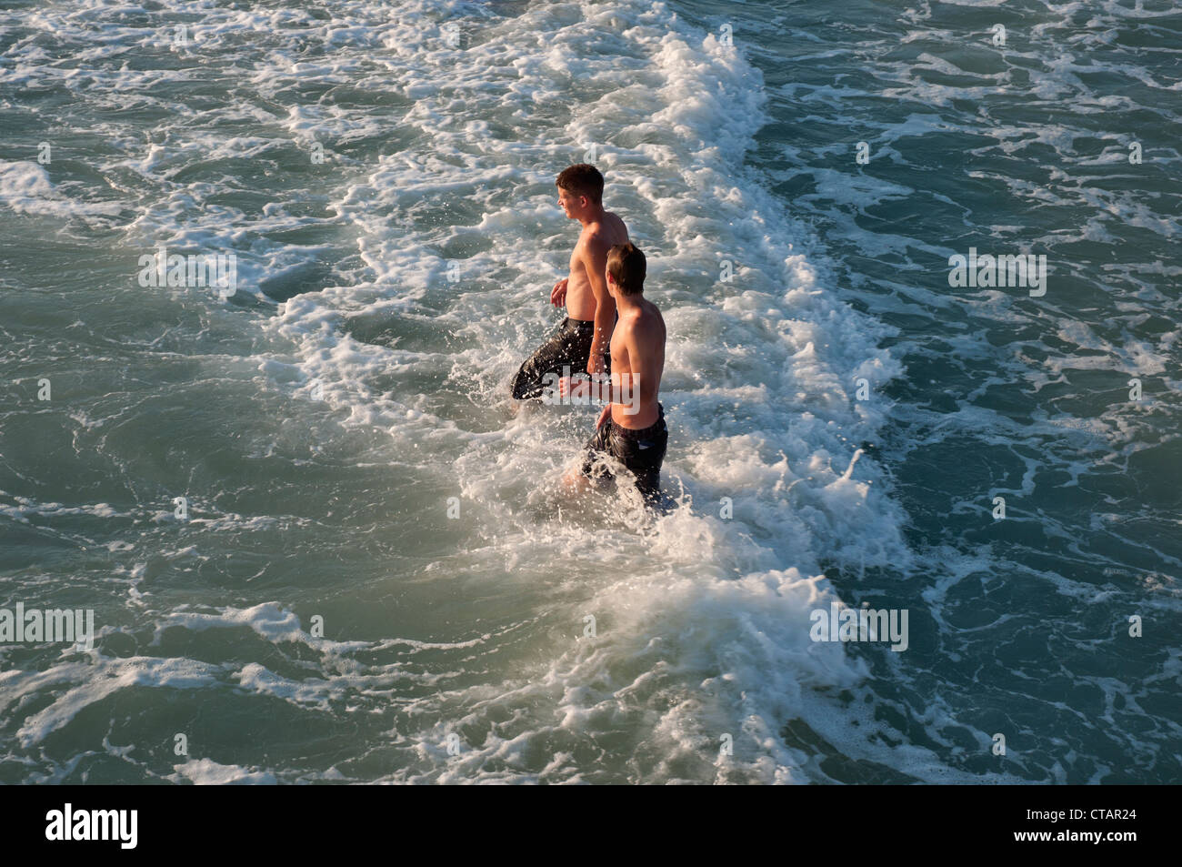 Two young men enjoying a late afternoon dip in the Gulf of Mexico at ...