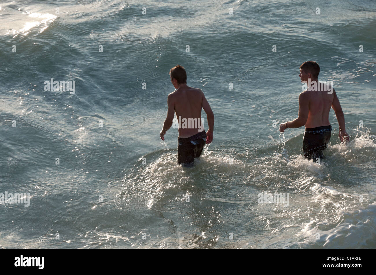 Two young men enjoying a sunset dip in the Gulf of Mexico at Naples ...