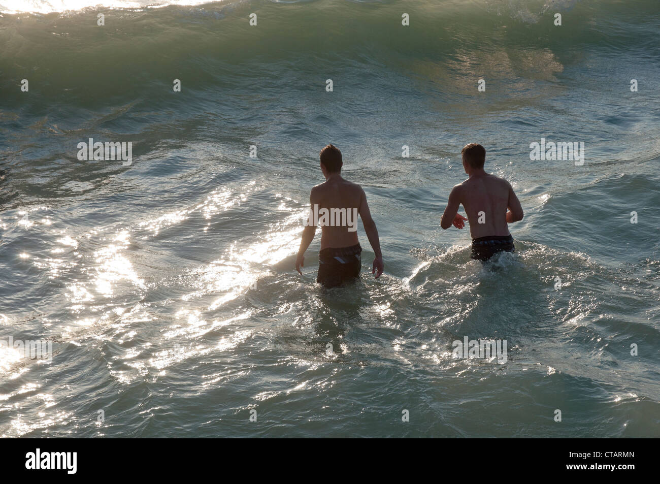 Two young men enjoying a sunset dip in the Gulf of Mexico at Naples ...