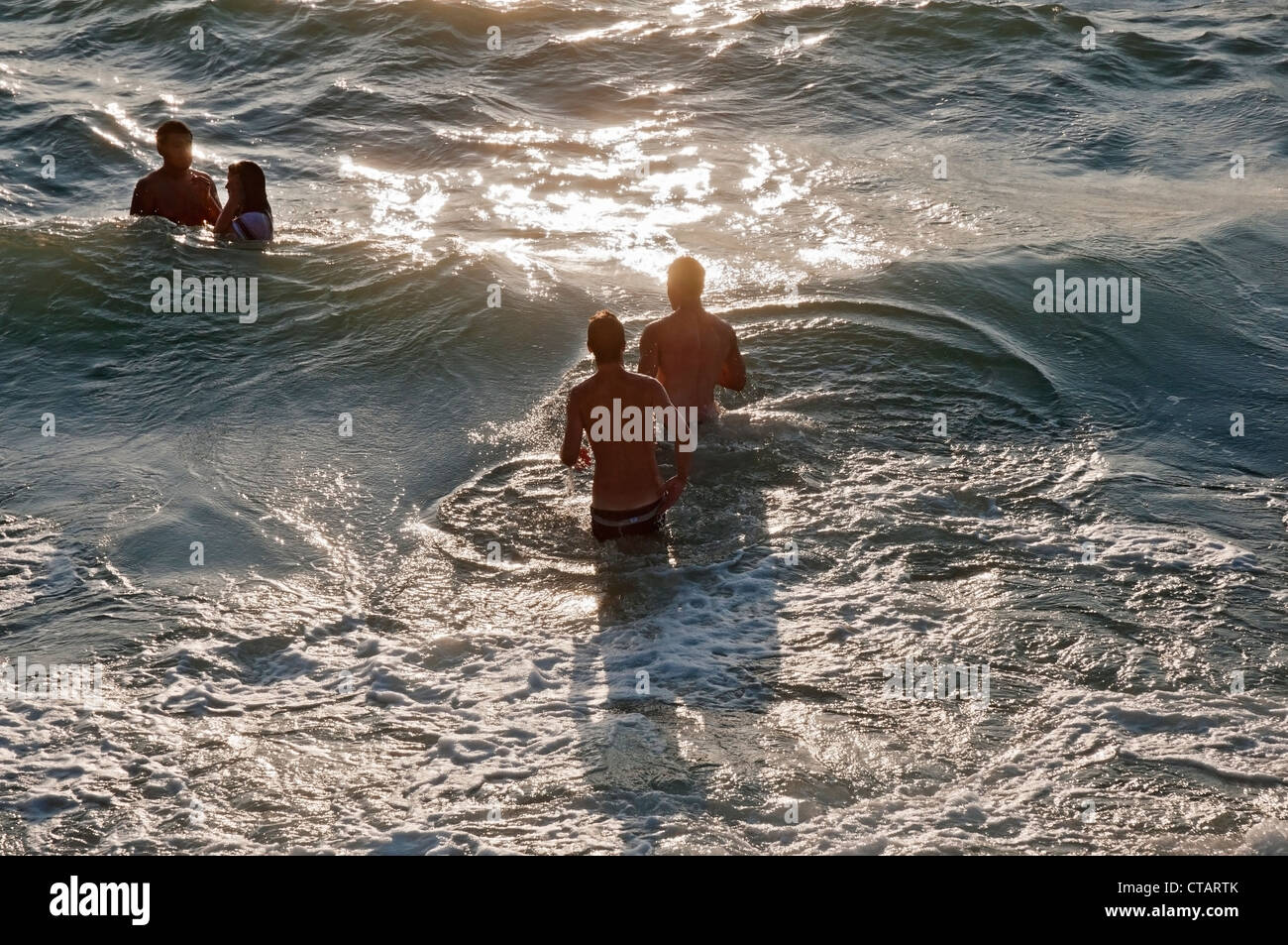 Young people enjoying a sunset dip in the Gulf of Mexico at Naples ...