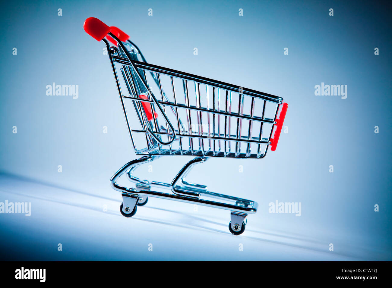 Empty shopping cart on the blue Stock Photo - Alamy