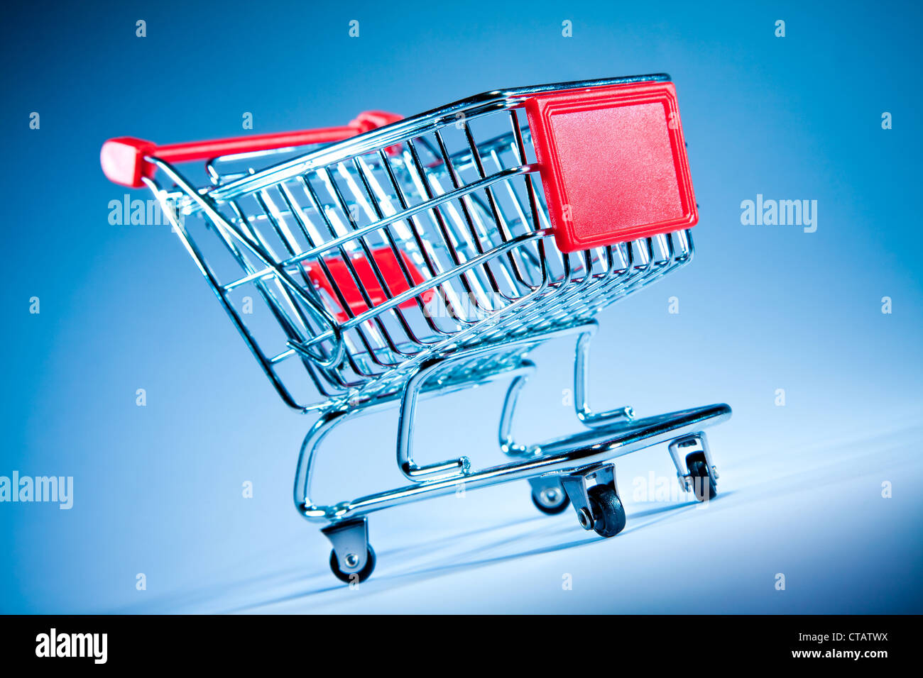 Empty shopping cart on the blue Stock Photo - Alamy