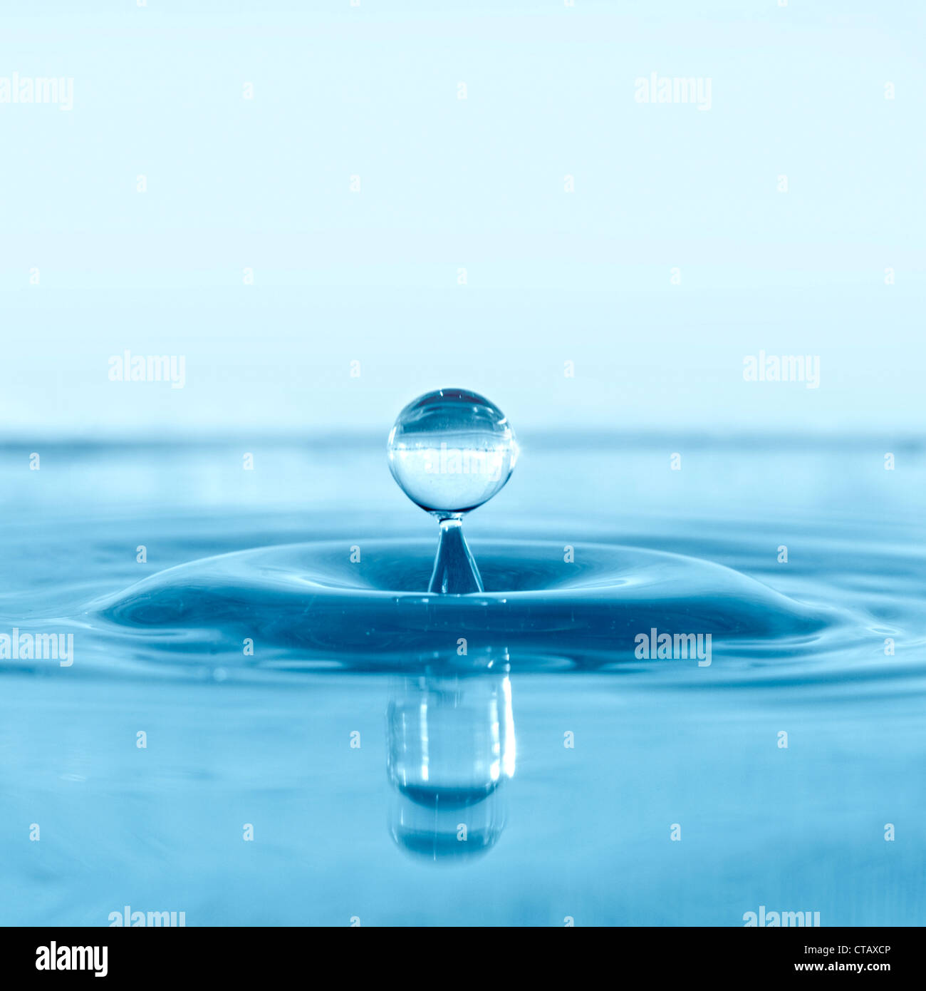Falling drop of blue water Stock Photo - Alamy
