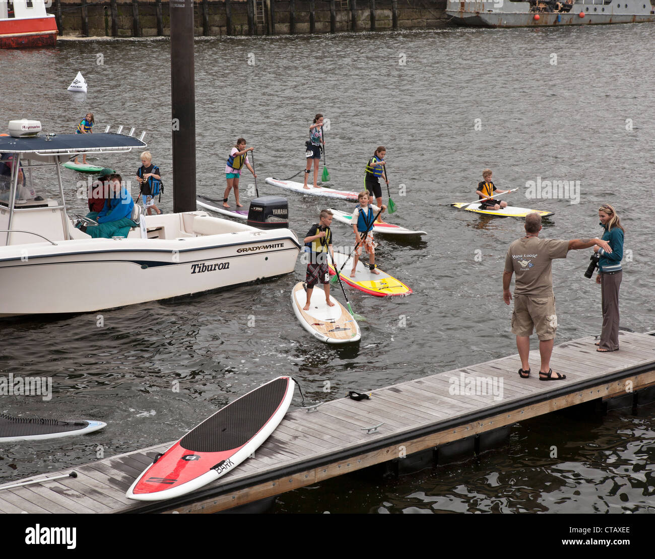 Kids practice their stand up paddle boarding in one of Boston's harbors ...
