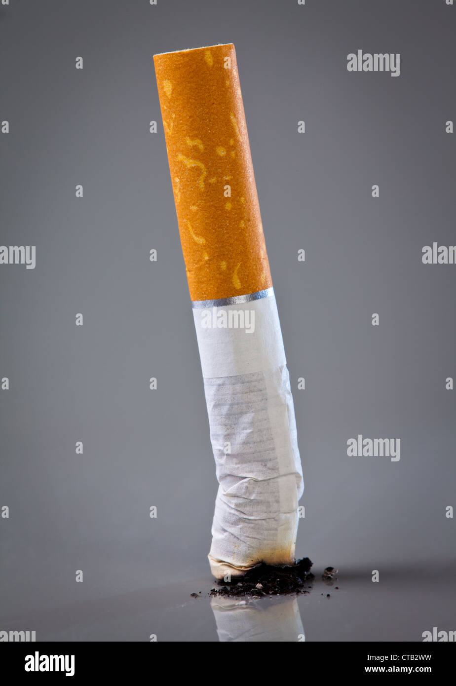 cigarette end on a grey background Stock Photo - Alamy