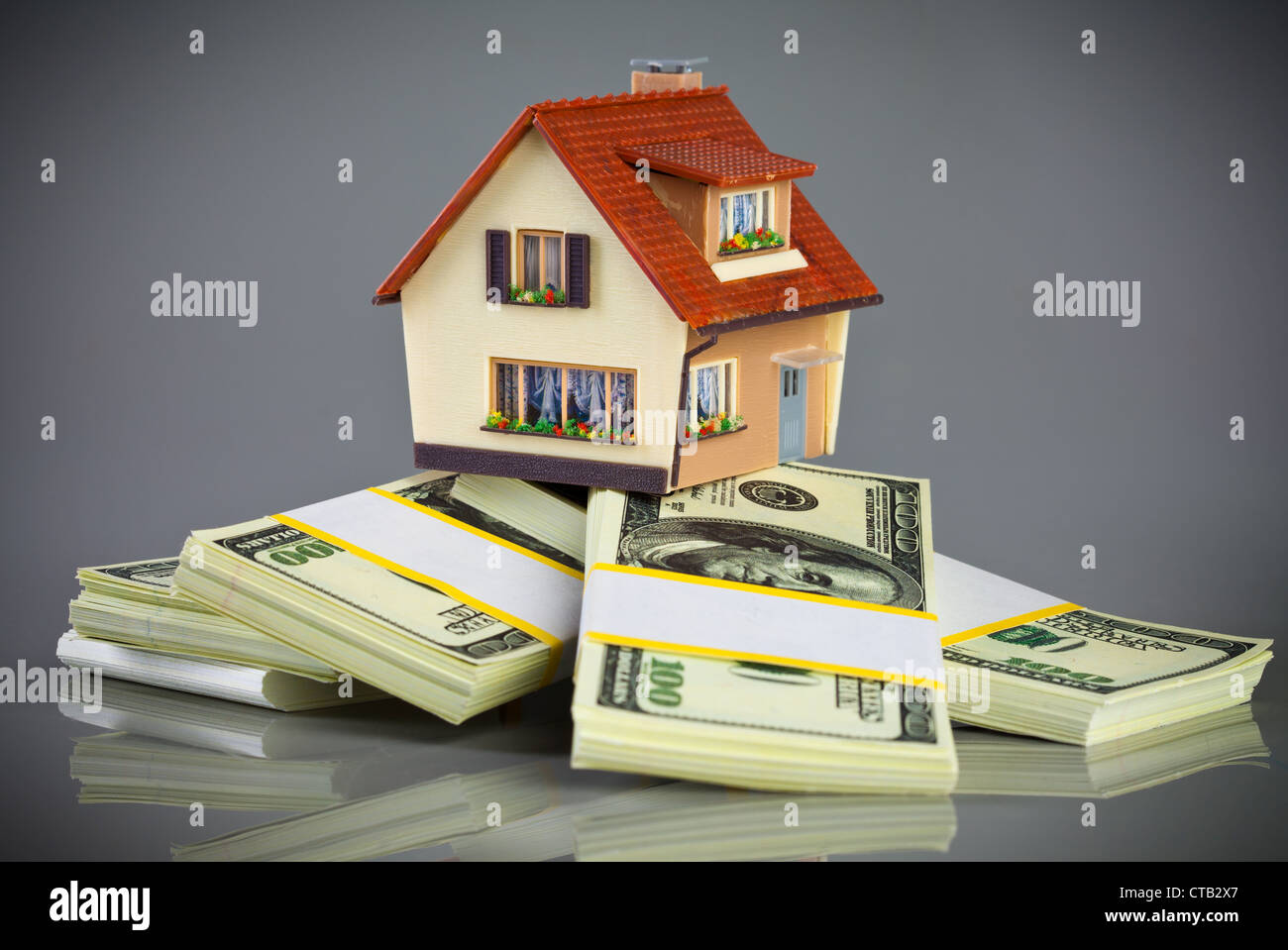 house on packs of banknotes on a grey background Stock Photo - Alamy