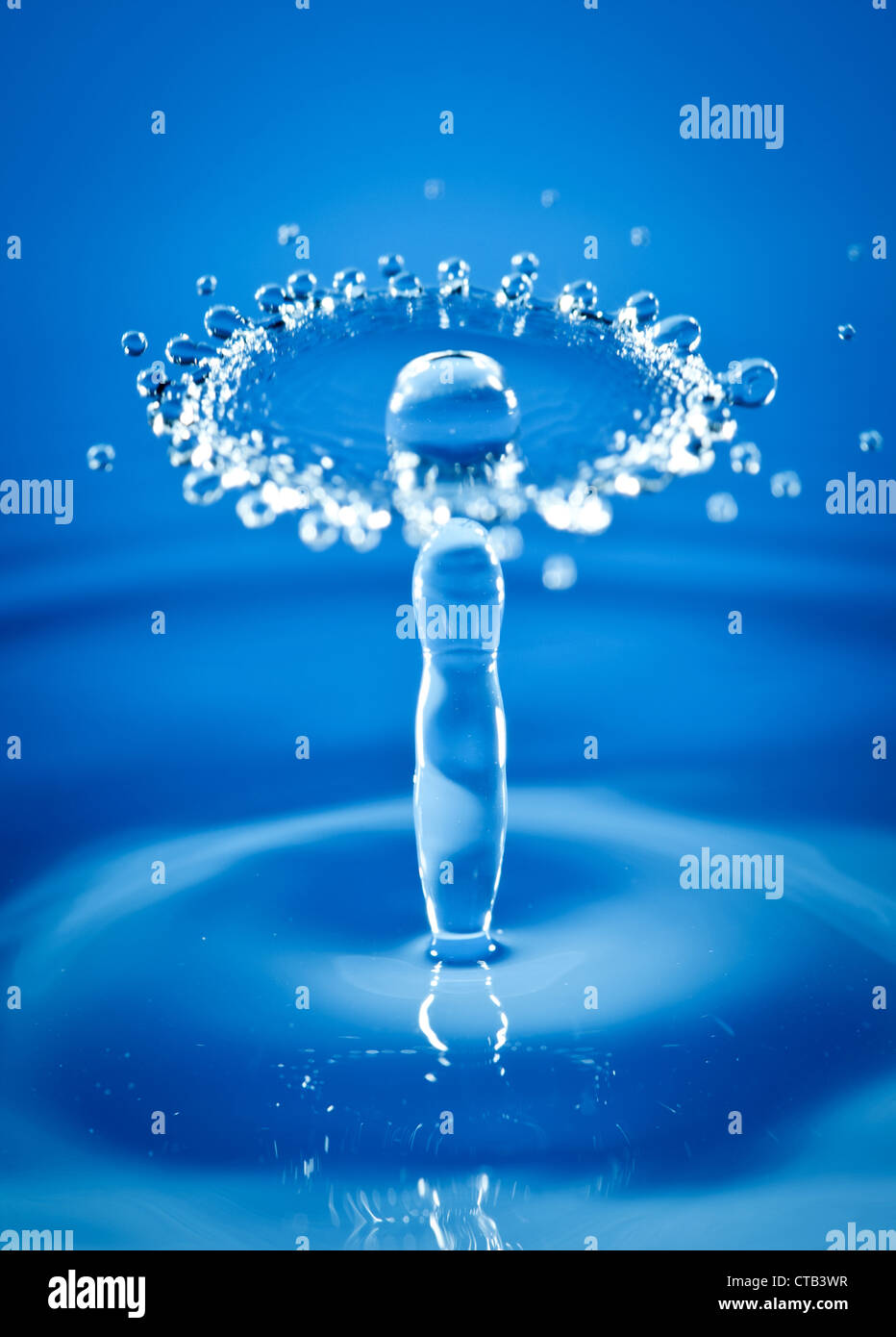 water drop falls downwards breaking about a drop Stock Photo - Alamy