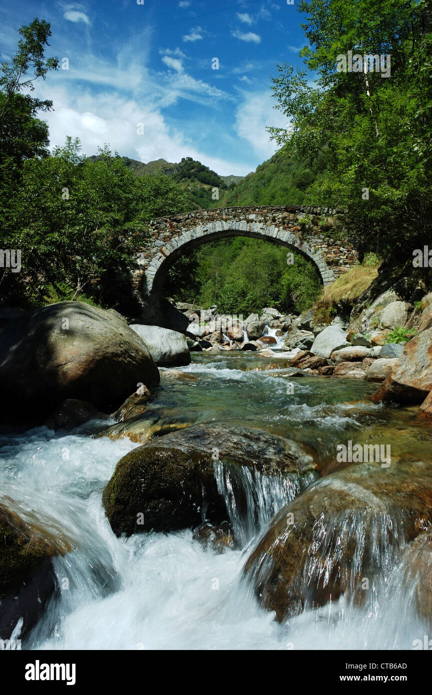 Aged arch bridge over a small mountain river Stock Photo - Alamy