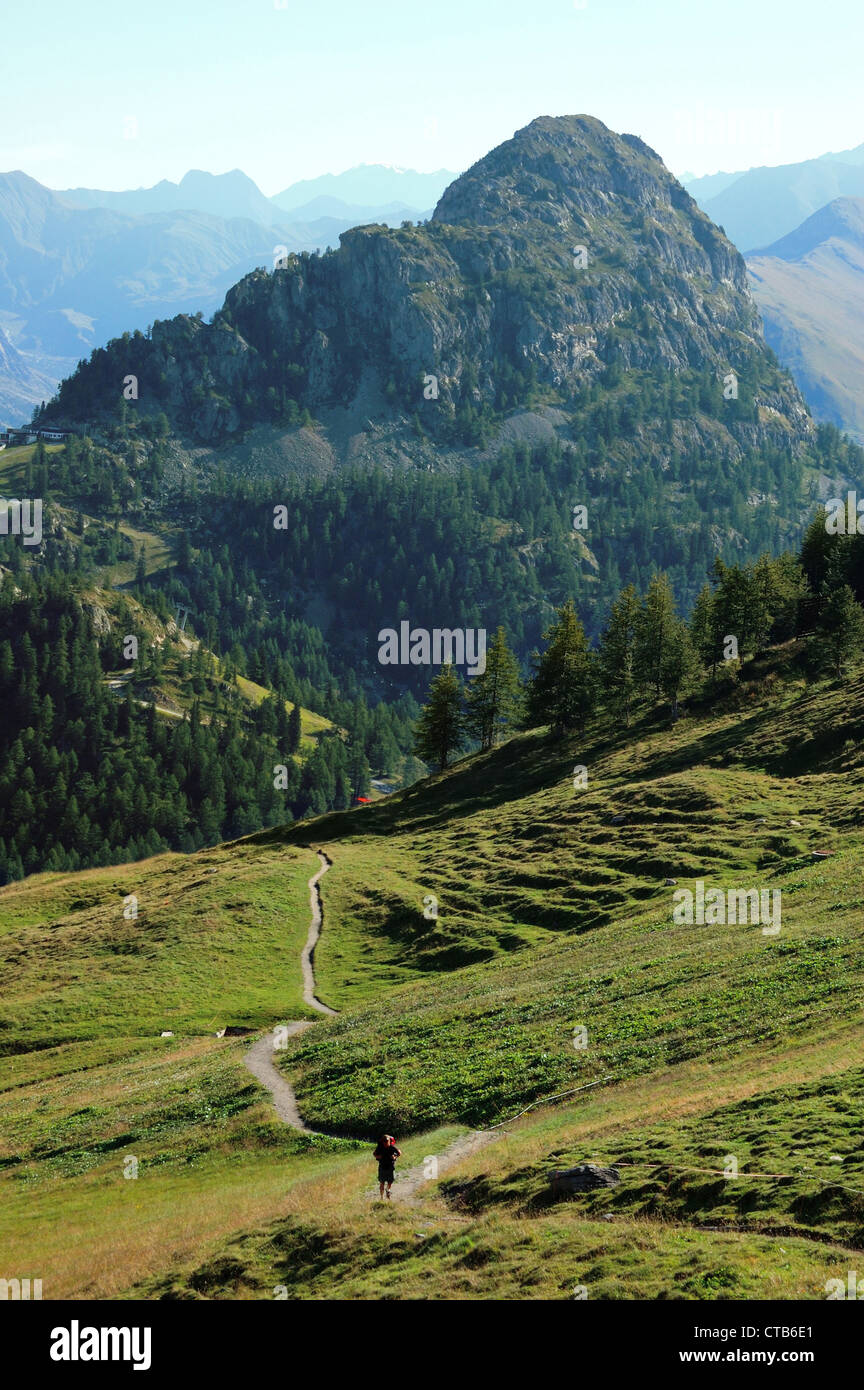 Trekker walking along a mountain path, Mont Blanc valley, west Alps ...