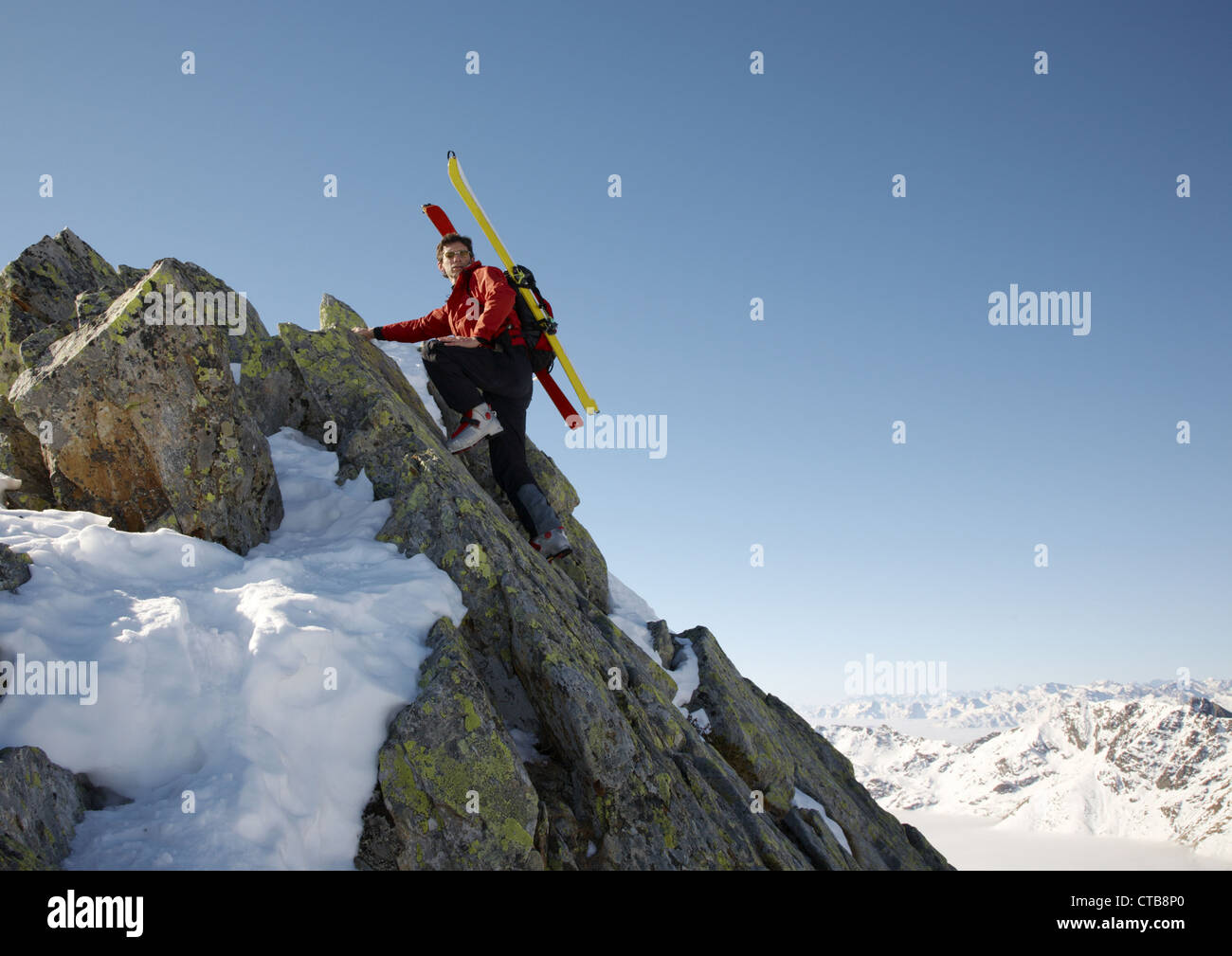 Male ski-climber climbing a rocky ridge; horizontal frame. Italian alps ...