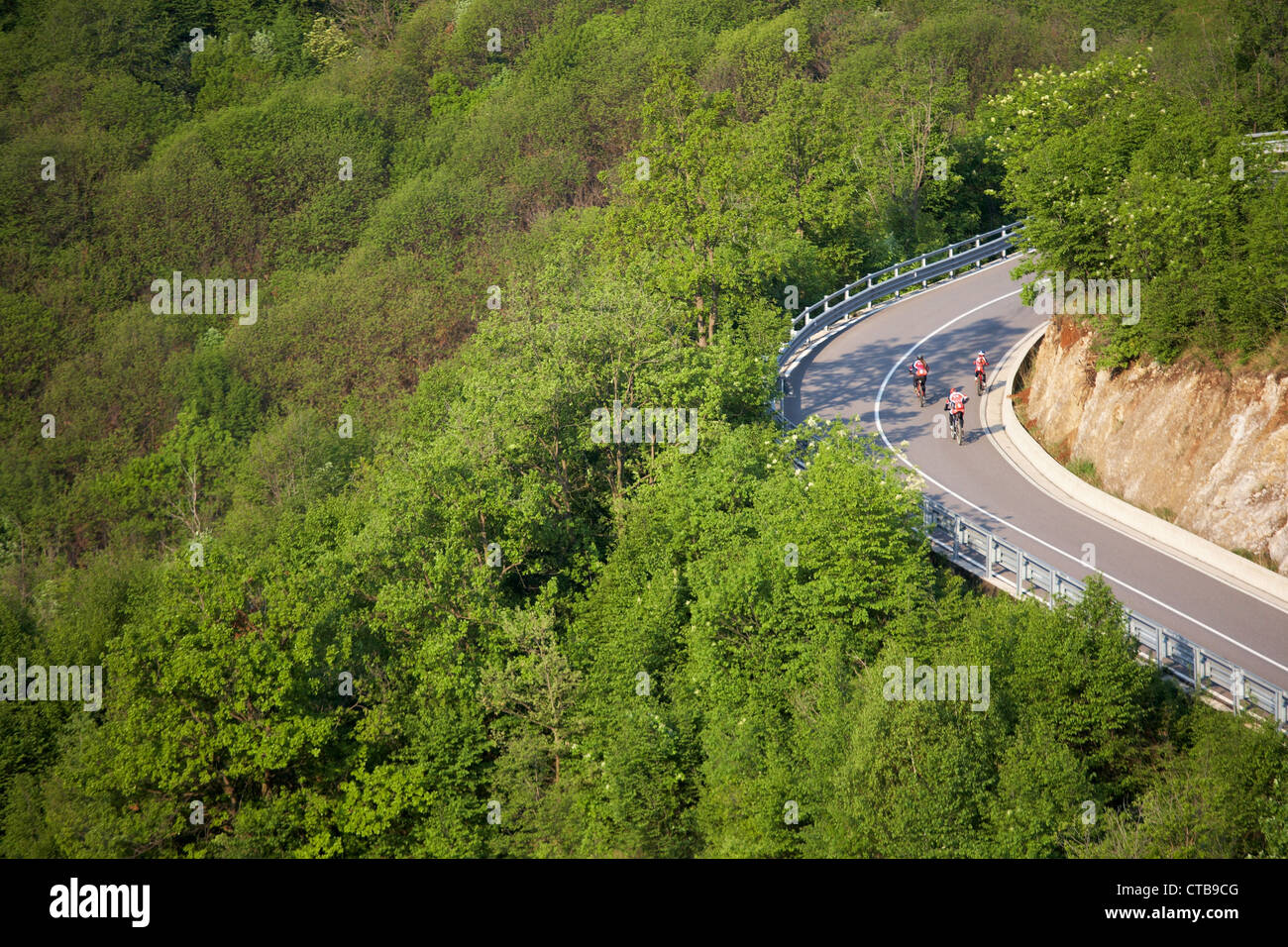 Steep road with serpentines with cyclist, Italy Stock Photo - Alamy