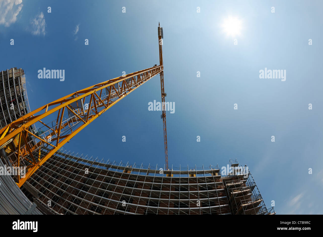 Fisheye lens looking up at construction crane and building; back-light ...