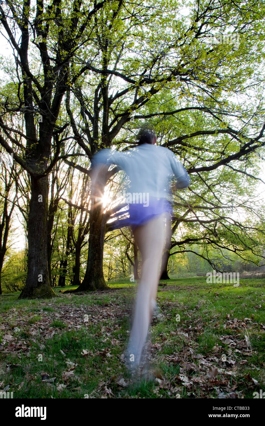 Young man trail running in a forest, blur effect Stock Photo - Alamy
