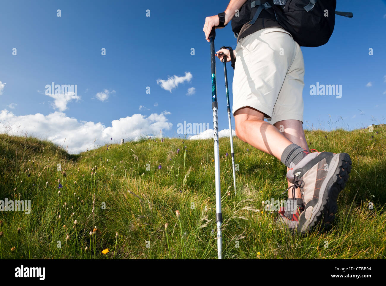 Male hiker walking along a mountain path. Horizontal orientaion. Low ...