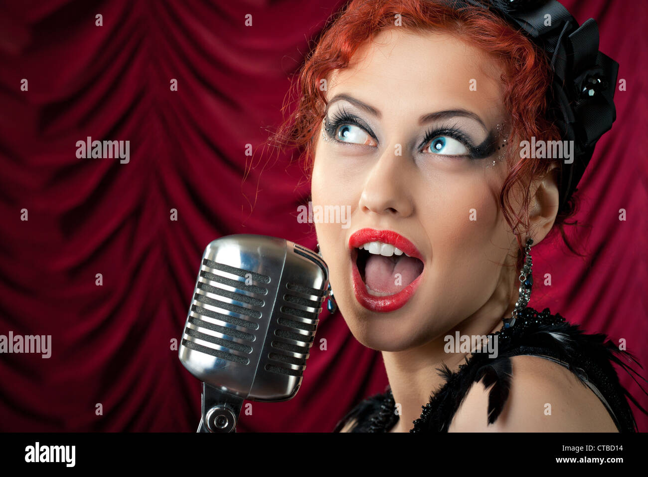 beautiful redhead woman singing into vintage microphone Stock Photo - Alamy
