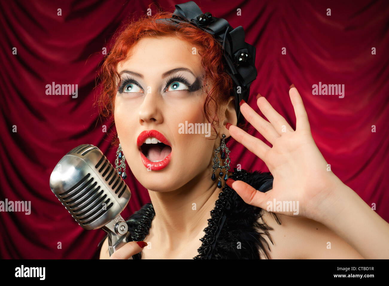 beautiful redhead woman singing into vintage microphone Stock Photo - Alamy