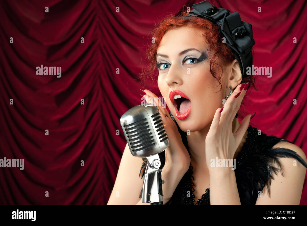 beautiful redhead woman singing into vintage microphone Stock Photo - Alamy