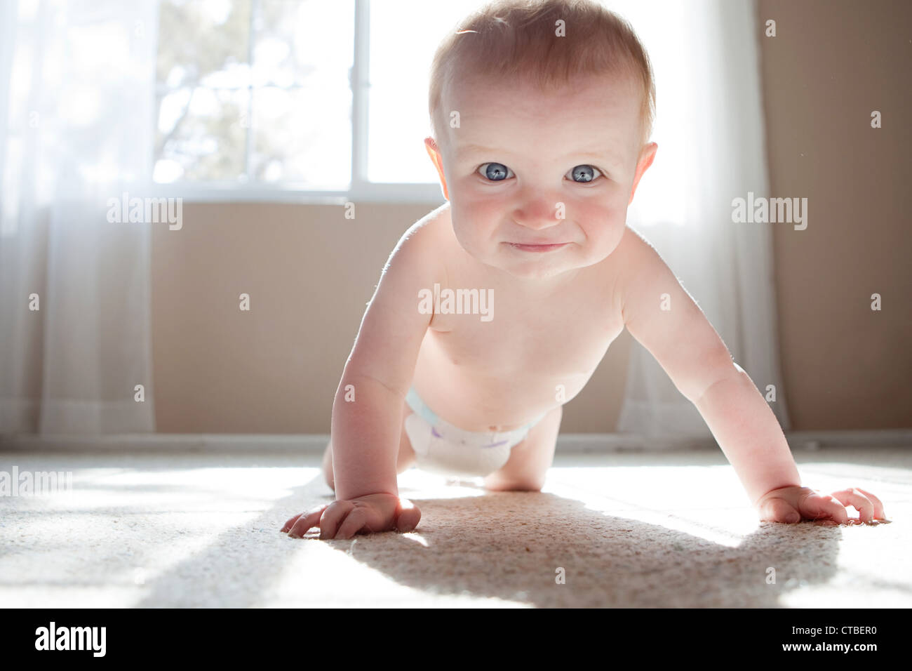 Young boy learning to crawl Stock Photo - Alamy