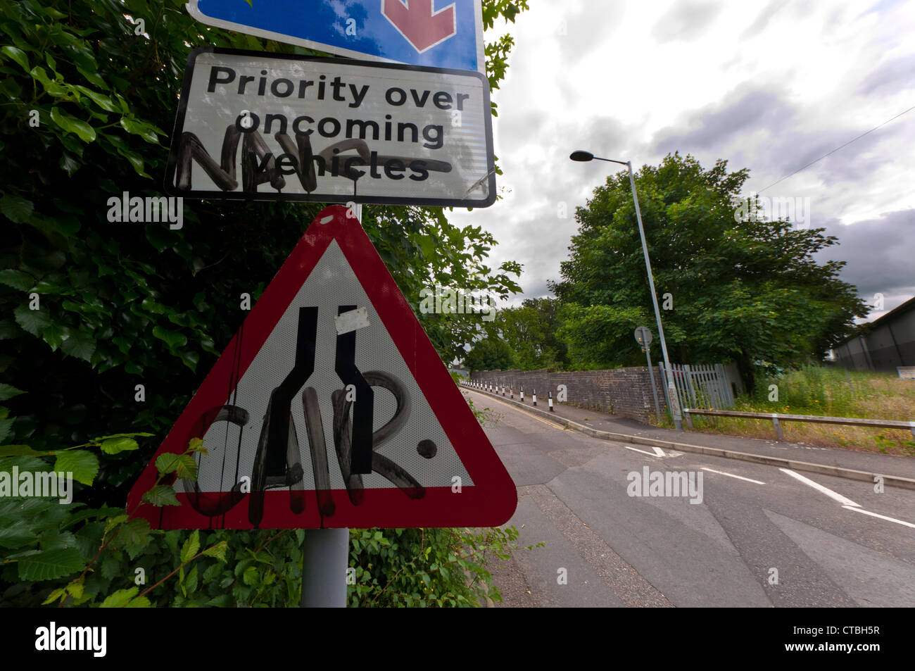 Road narrows road sign with graffiti Stock Photo - Alamy