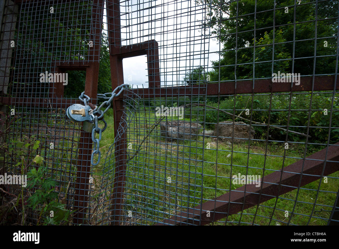 wasteland with padlocked gate Stock Photo - Alamy