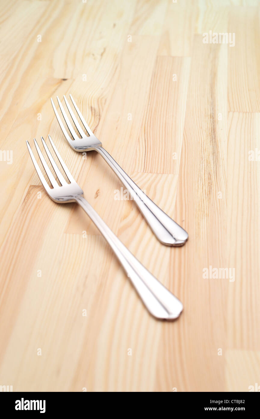 two fork on a kitchen pinewood table closeup Stock Photo - Alamy