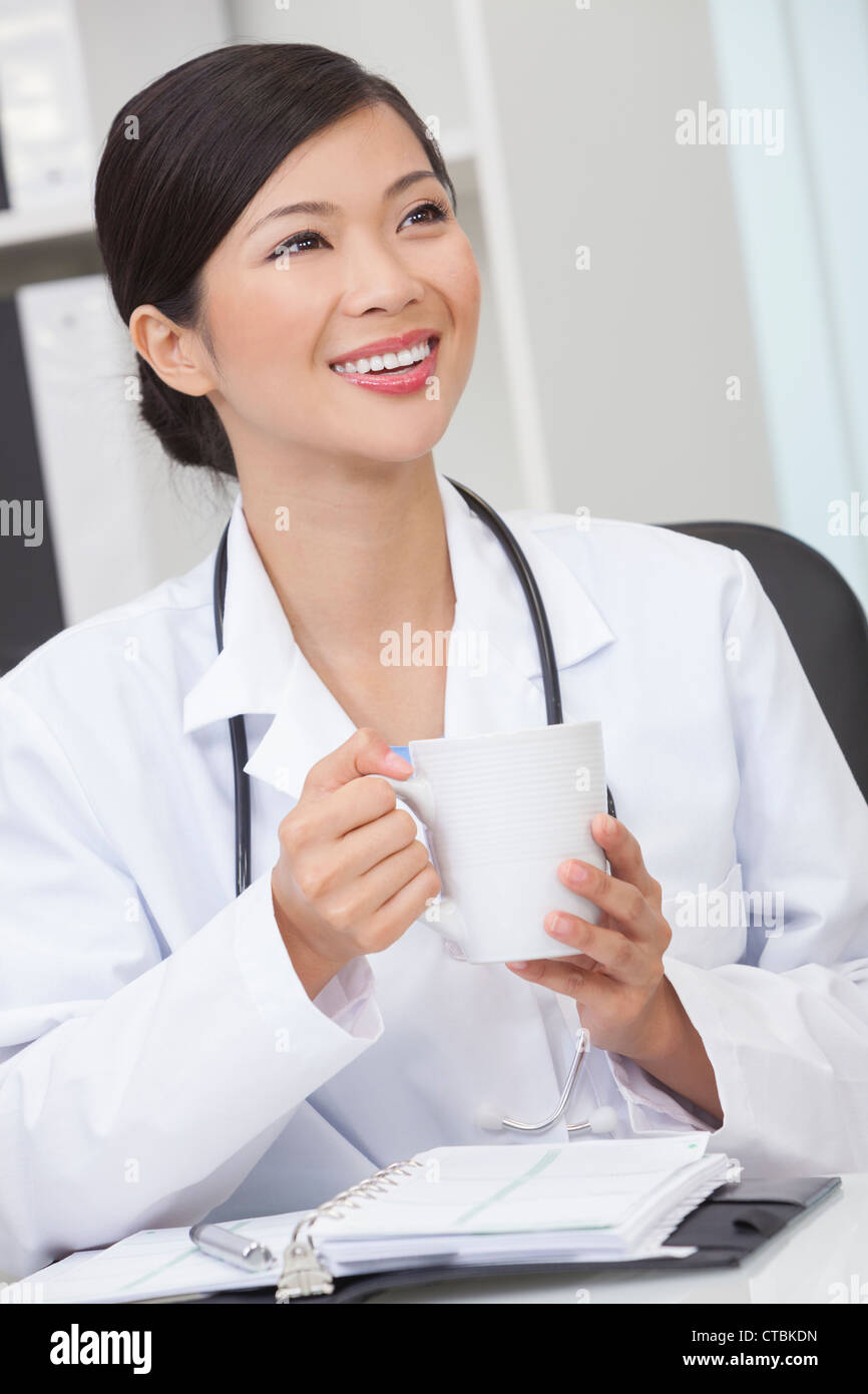 A Chinese Asian female medical doctor drinking tea or coffee in a ...