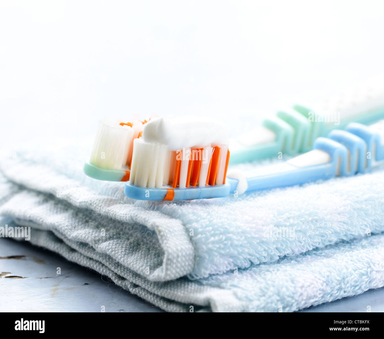 Couple toothbrushes with toothpaste on a towel Stock Photo - Alamy