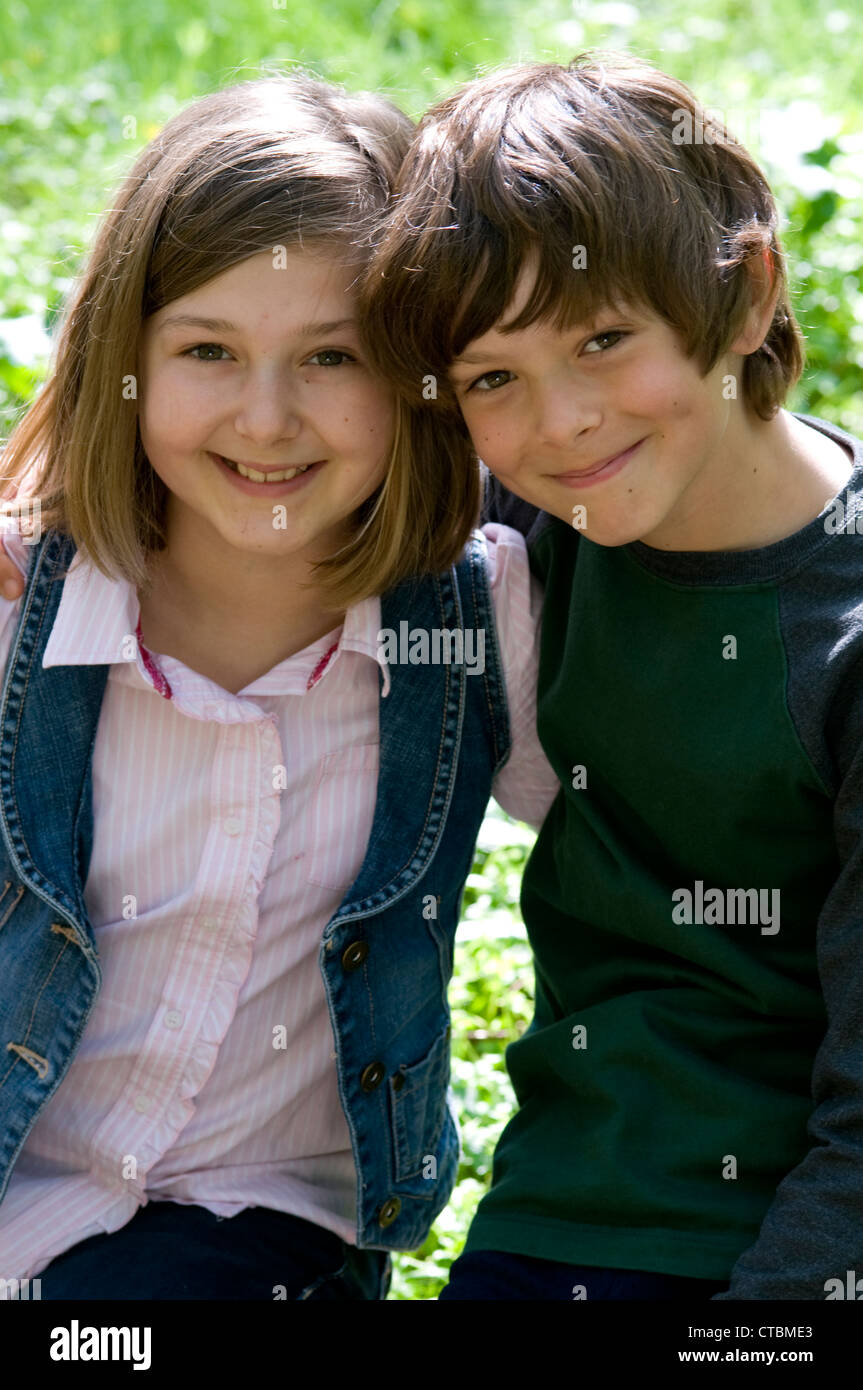 Portrait Of A Brother And Sister Smiling With Their Arms Around Each