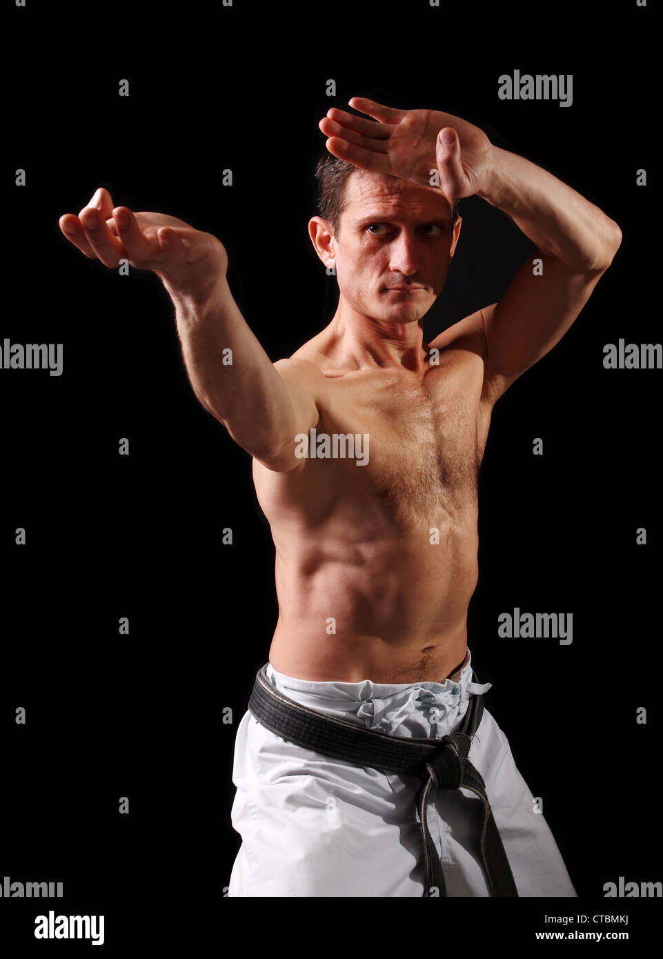 Karate. Man in a kimono with a black background Stock Photo - Alamy