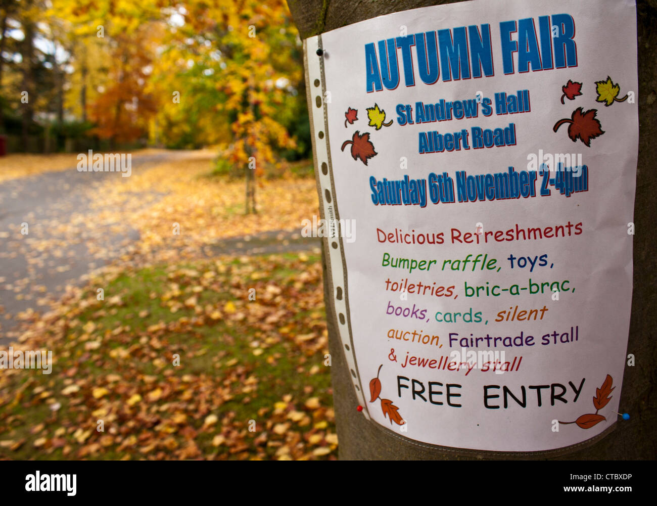 A notice on a tree announcing an Autumn Fair against a background of ...