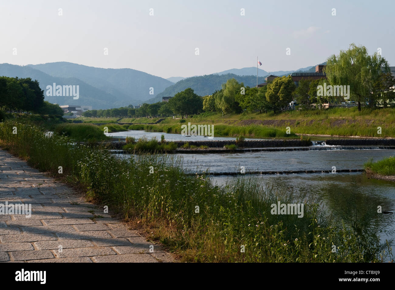 The quiet path along the banks of the Kamo River in Kyoto, Japan, a ...