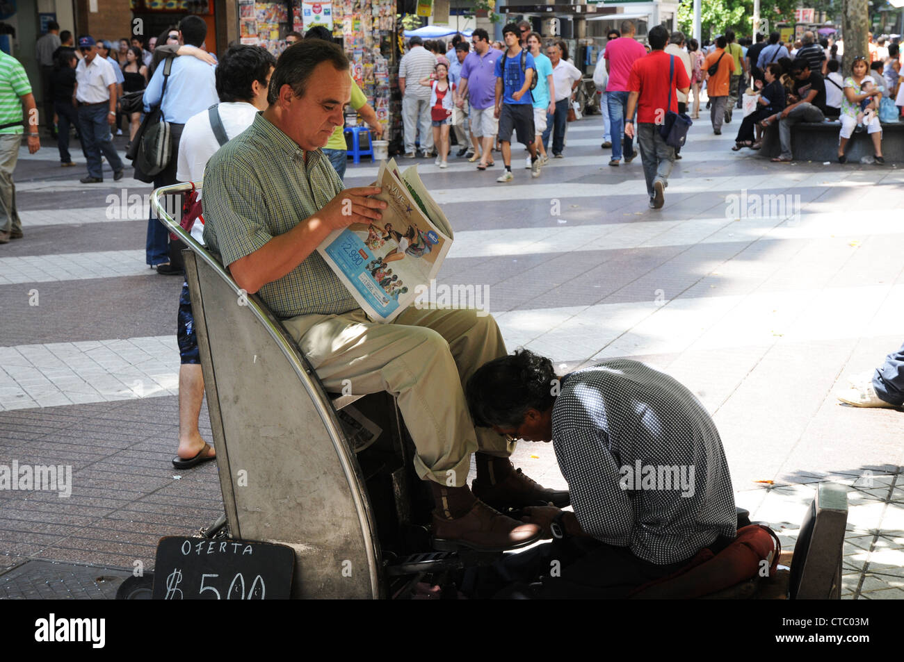 Shoe shine boy, shoe cleaner, man sitting in steel chair reading ...